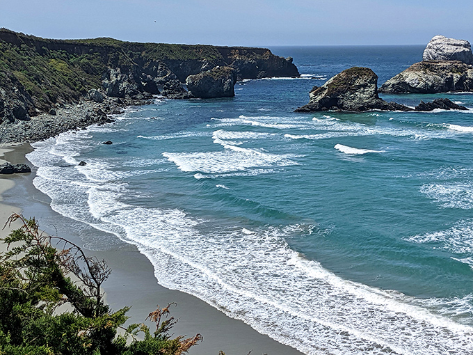 Turquoise waves kiss dark sand where a freshwater creek meets the mighty Pacific in spectacular fashion.