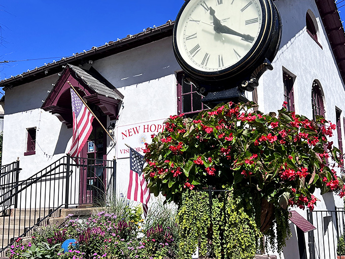 The New Hope Visitors Center stands proudly with its clock and flowering plants. This white building serves as the perfect starting point for exploring this artsy riverside town.