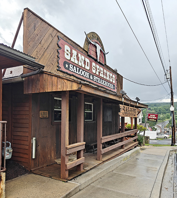 The rustic charm of Sand Springs Saloon stands proud against mountain skies. John Wayne would feel right at home on that well-worn porch.
