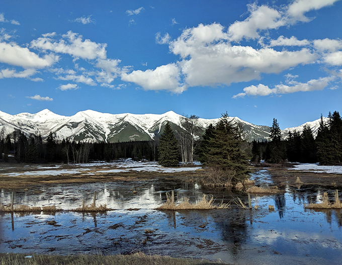 Nature's masterpiece on display! Seeley Lake's pristine waters flow through meadows with mountains standing guard.