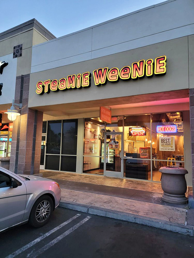 As evening falls, Steamie Weenie's illuminated sign glows like a beacon for hot dog enthusiasts seeking steamed perfection.