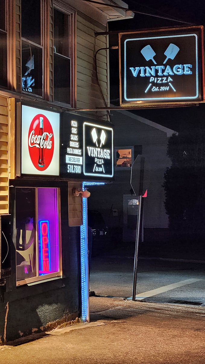 By day, a simple storefront. By night, those neon lights transform Vintage Pizza into a beacon for the pizza-obsessed.