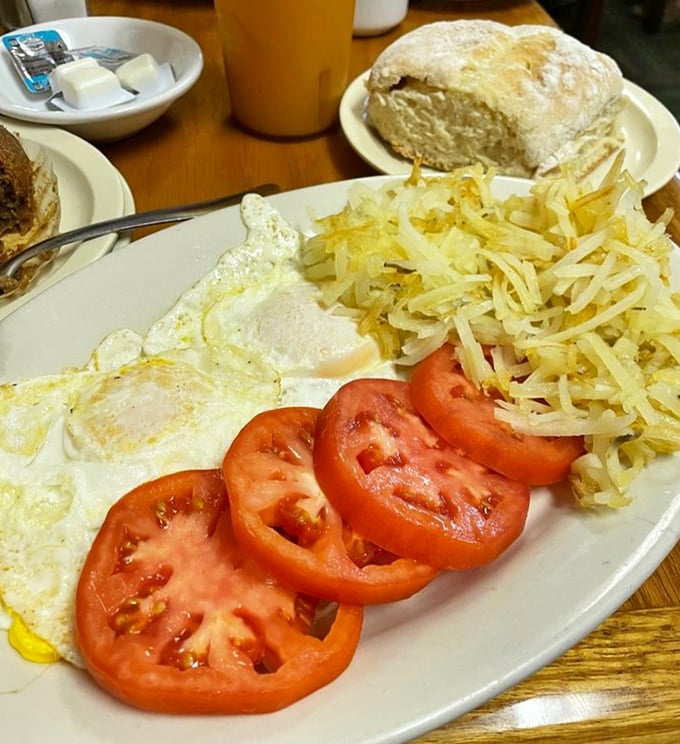 Eggs sunny-side up with crispy hash browns and fresh tomatoes&mdash;proof that sometimes the simplest breakfasts deliver the most profound satisfaction.
