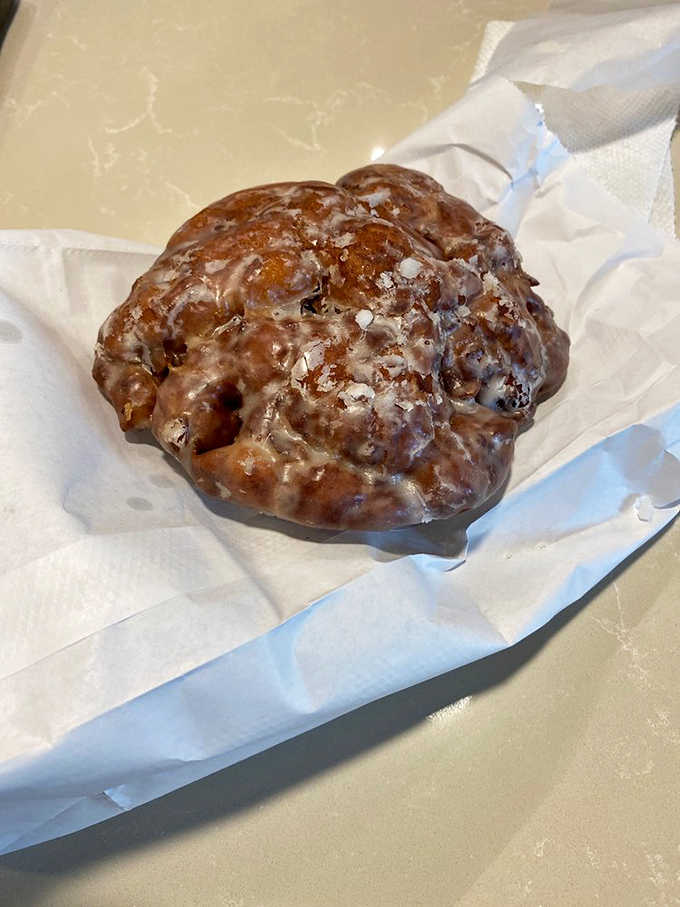 The legendary apple fritter &ndash; a glistening, craggly masterpiece where each crevice captures glaze like nature's perfect sugar trap.