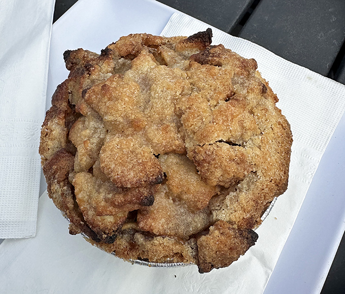 This isn't just apple pie—it's edible architecture. The golden-brown dome of buttery crust practically whispers, "Resistance is futile, just bring ice cream."