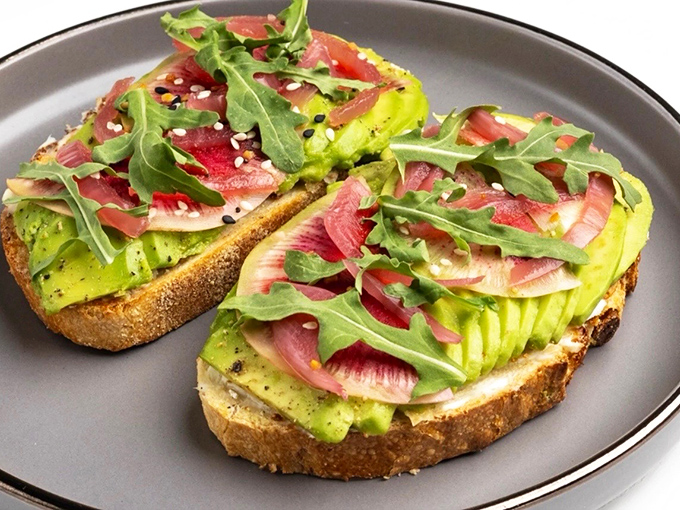 Avocado toast that's dressed better than most people at fashion week&mdash;complete with vibrant greens, radishes, and what appears to be a sprinkling of culinary magic.