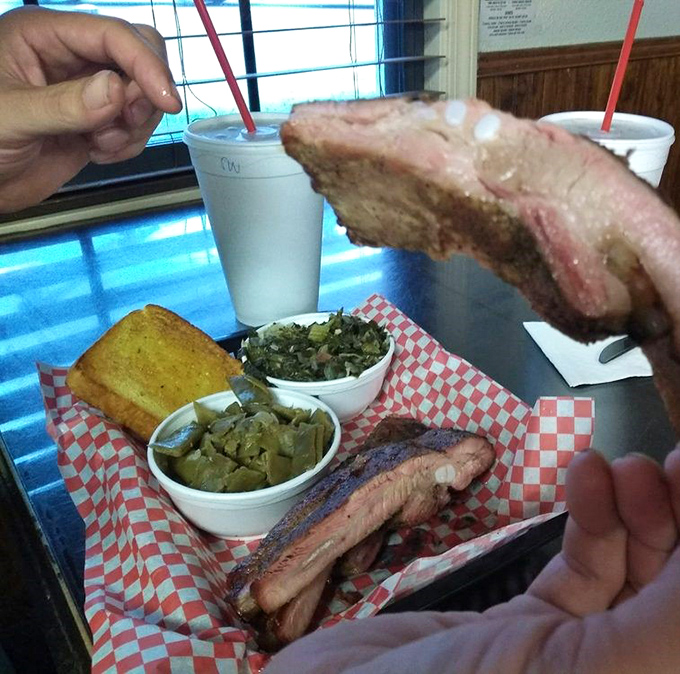 Behold: ribs with the perfect pink smoke ring that BBQ aficionados dream about. Those collard greens aren't just a side&mdash;they're a supporting actor deserving their own award.