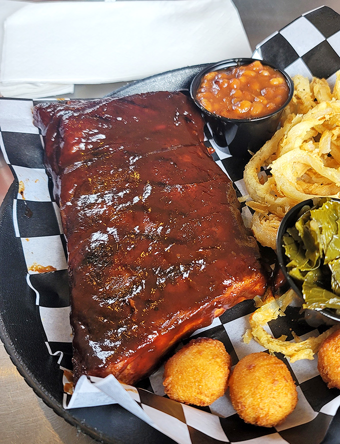 These ribs glisten like mahogany treasure, each one a masterclass in the ancient art of smoke and patience.
