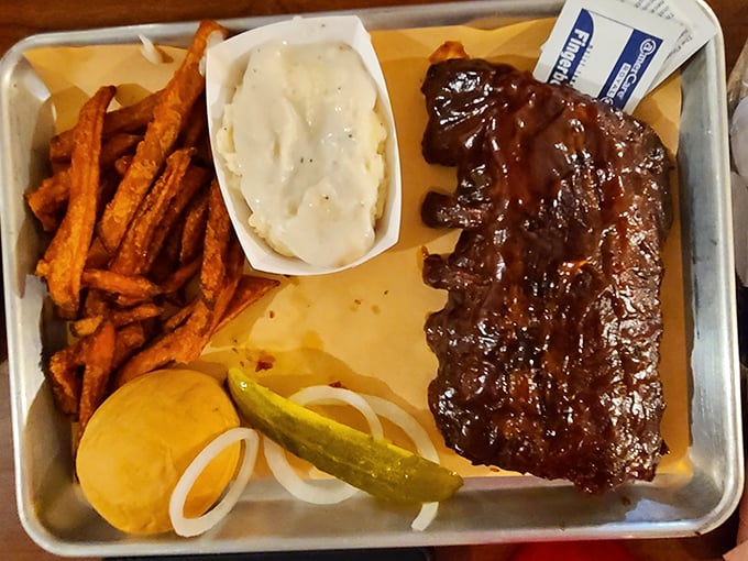 Baby back ribs glistening with sauce that would make vegetarians question their life choices. Served with sides that refuse to be upstaged.