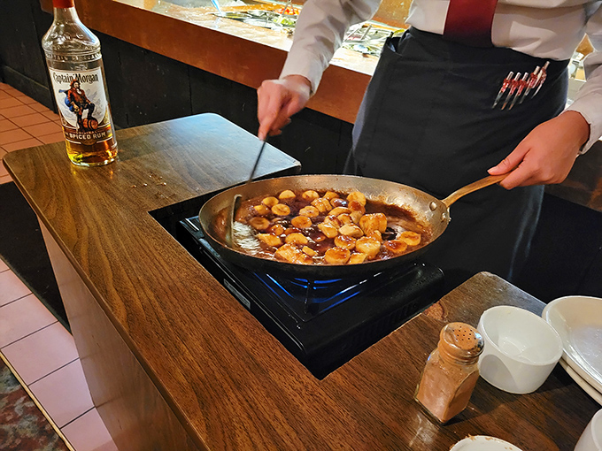 Skilled hands prepare a sizzling pan of savory delights, showcasing the culinary craftsmanship that makes Sperry's dining experience exceptional.