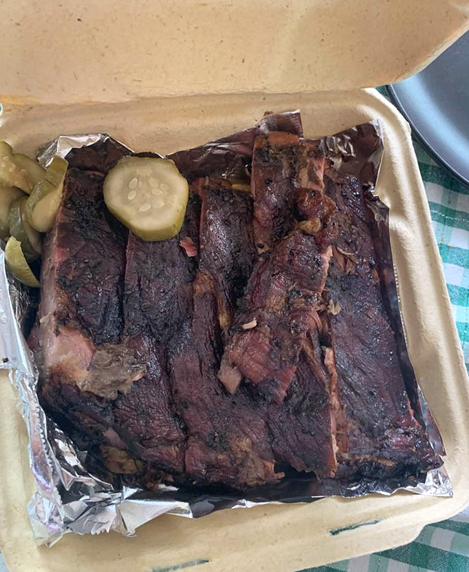 These ribs don't just fall off the bone—they practically leap into your mouth, trailing smoke rings and bark so perfect it deserves its own art exhibition.