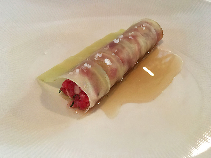 This isn't just beef tartare; it's a delicate work of art wrapped in translucent slices with perfect salt crystals standing guard.