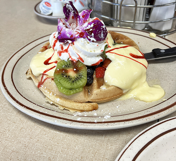 This isn't just a waffle&mdash;it's edible art. Fresh fruit, whipped cream, and a delicate orchid transform breakfast into a celebration worthy of your Instagram feed.