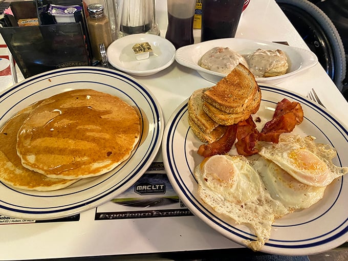 Behold, the breakfast of champions! A golden pancake with the perfect tan lines, eggs with personality, and bacon that's achieved crispy perfection.