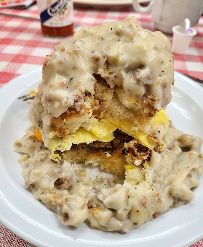 Behold the main event: biscuits and gravy stacked like a savory Jenga tower that dares you not to dive in face-first.