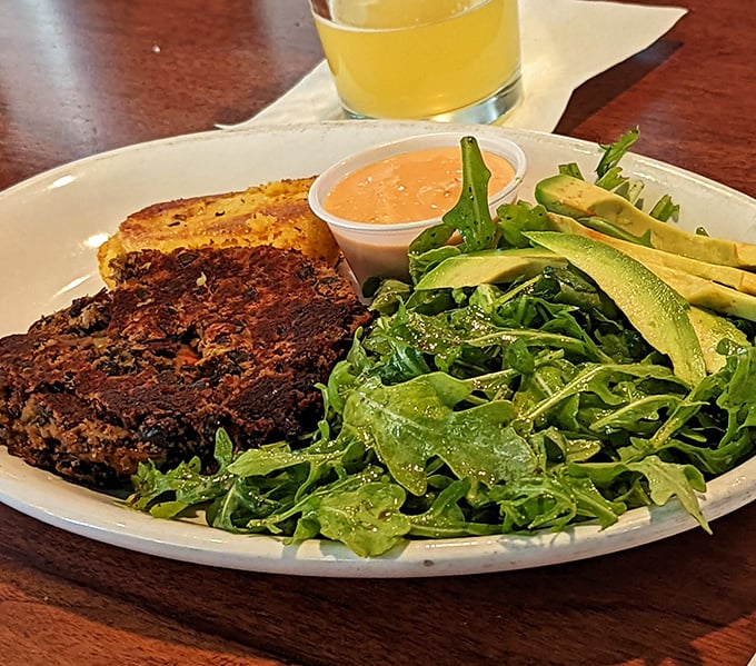 The legendary black bean burger arrives like a work of art. That crispy cheese cake and fresh arugula aren't just garnishes&mdash;they're co-stars in this vegetarian masterpiece.