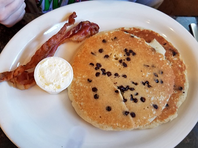 Blueberry pancakes with a side of bacon &ndash; proof that sometimes the simplest pleasures are the most profound. That butter pat is just waiting for its moment.