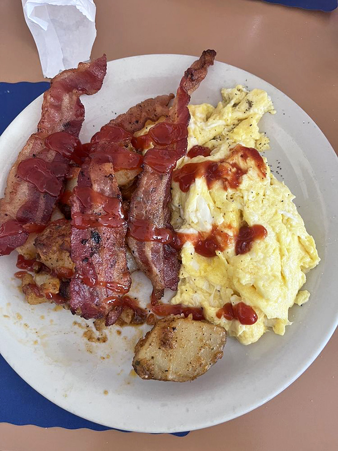 Breakfast nirvana achieved: perfectly scrambled eggs with a touch of hot sauce and bacon cooked to that magical point between chewy and crisp.