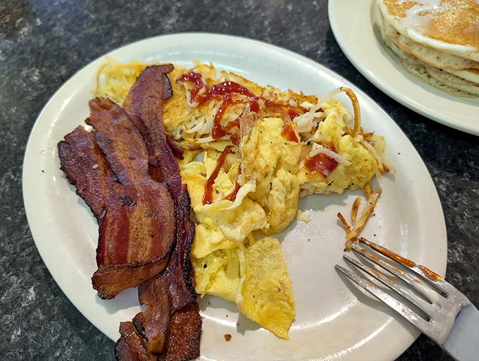 Perfectly crisp bacon alongside fluffy scrambled eggs&mdash;breakfast fundamentals executed with the precision of a Vegas card dealer.