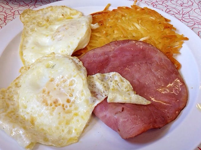 Breakfast perfection on a plate &ndash; sunny eggs, thick-cut ham, and hash browns that achieve that elusive balance of crispy exterior and tender interior.