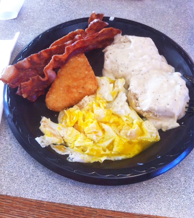 Breakfast nirvana on a plate: perfectly scrambled eggs, crispy bacon, and country-fried steak smothered in peppery gravy that would make your grandmother weep with joy.