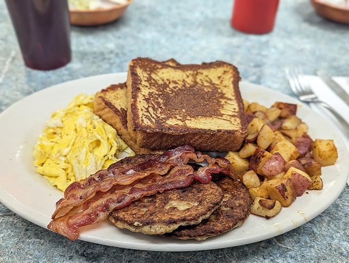 Breakfast perfection on a plate &ndash; golden eggs, crispy home fries, and French toast that makes you question why you ever eat anything else.