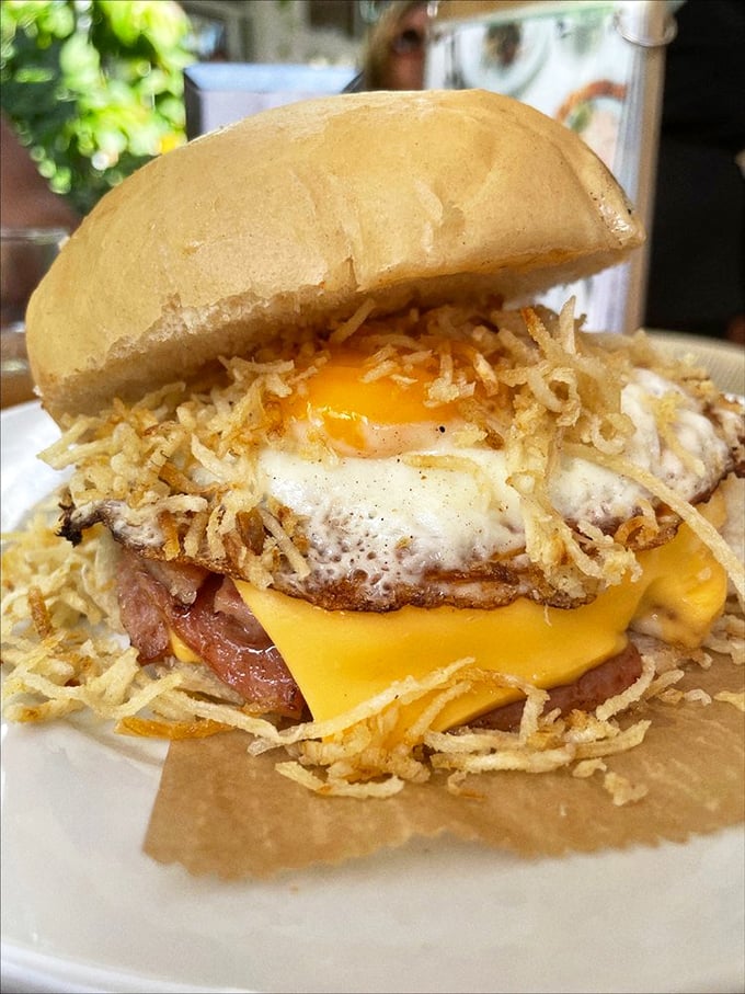 Behold the breakfast sandwich in all its glory! Runny egg, melty cheese, and those crispy potato sticks&mdash;a textural masterpiece on a bun.