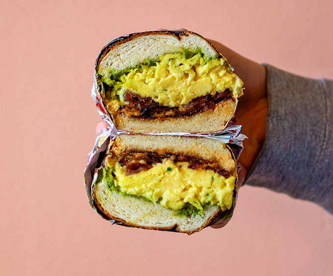 Breakfast sandwich perfection: golden eggs, vibrant avocado, and savory goodness nestled between toasted bread. This is why morning people exist.