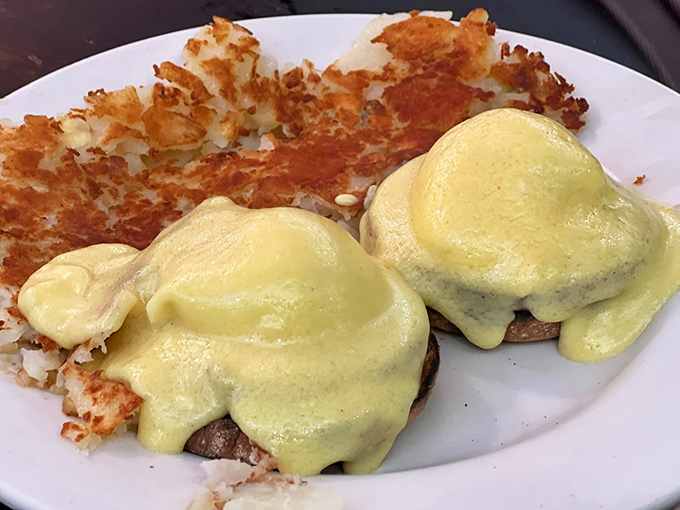 Eggs Benedict that would make a cardinal sin. Hollandaise cascades over perfectly poached eggs while crispy home fries stand guard nearby.