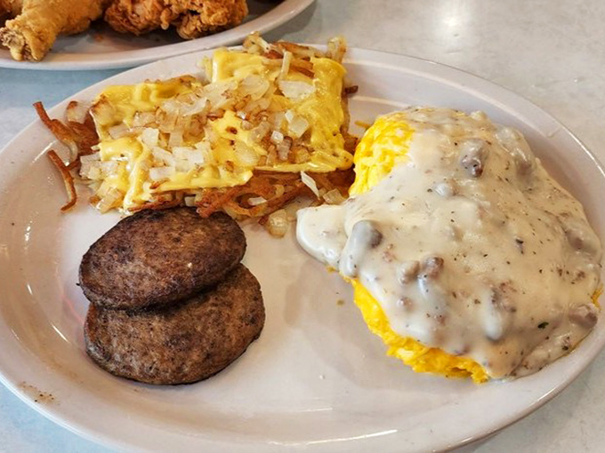 Breakfast nirvana arrives on a single plate&mdash;golden hash browns mingling with sausage patties while an omelet drowns happily under a blanket of country gravy.