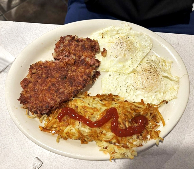 Breakfast alchemy at its finest: crispy hash browns, perfectly seasoned sausage patties, and eggs that would make a chicken proud.