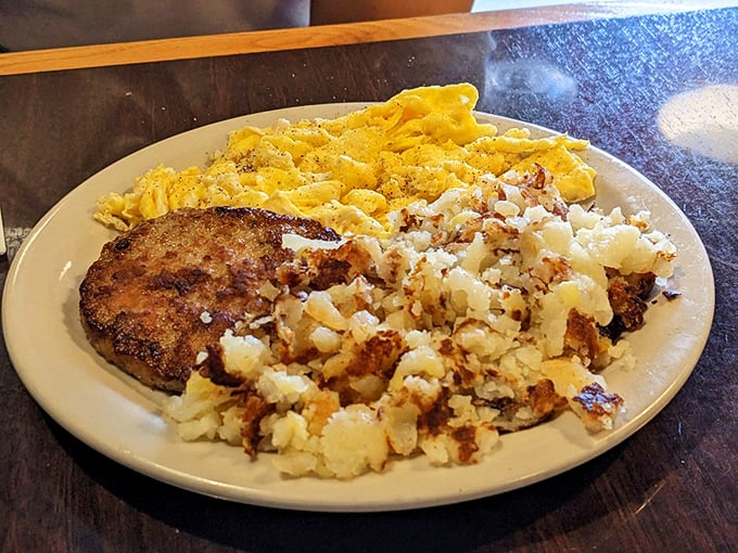 Breakfast alchemy at its finest: a perfectly seared pork chop alongside scrambled eggs and hash browns that could make a grown adult weep with joy.