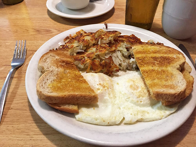 Breakfast perfection on a plate – golden toast, farm-fresh eggs, and hash browns that somehow maintain their crispiness despite the journey.