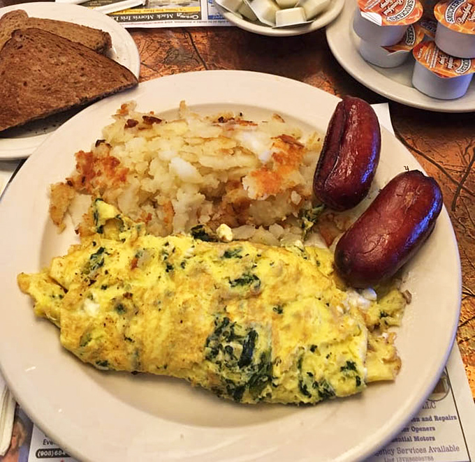 A perfectly executed spinach omelet that would make Popeye weep with joy, paired with home fries that achieve the golden-brown perfection we all aspire to in life.
