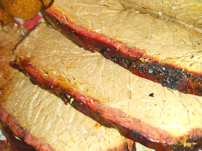 Behold the holy grail of barbecue: perfectly smoked brisket with that coveted pink smoke ring. This isn't just meat; it's a time-honored tradition sliced and served.