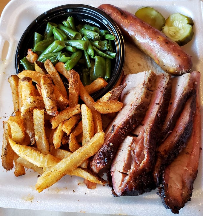 Brisket, fries, green beans, sausage, and pickles compose a plate that could bring world peace through pure deliciousness.