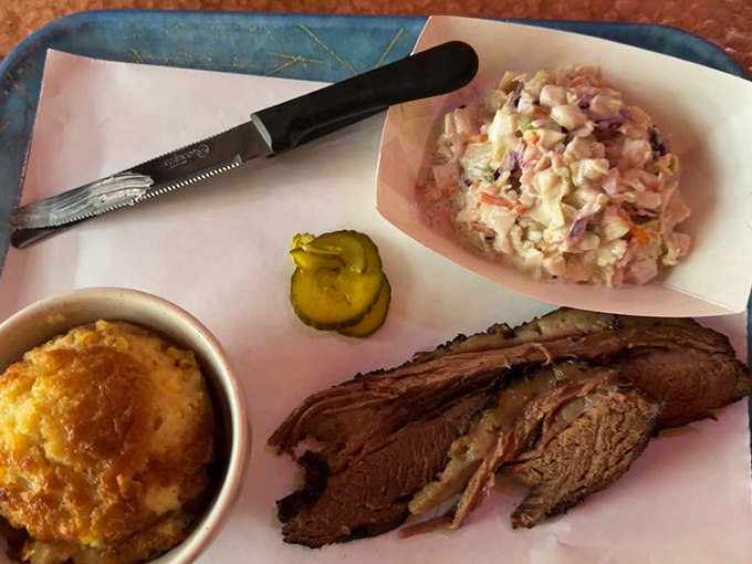 Behold the holy trinity of BBQ perfection: tender brisket with that coveted smoke ring, creamy mac and cheese, and coleslaw that actually deserves a place at the table.