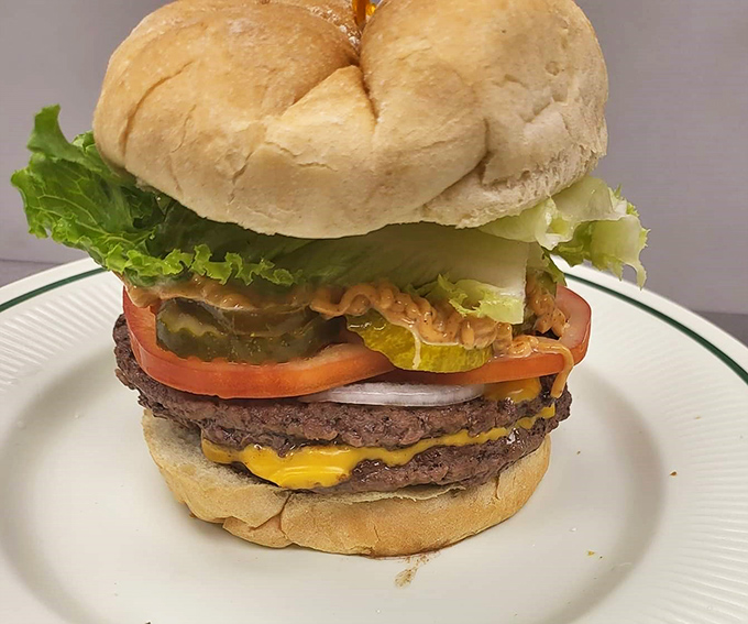This isn't just a burger; it's architecture. Notice how those layers of beef, cheese, and fresh toppings create a skyscraper of satisfaction that requires both hands.