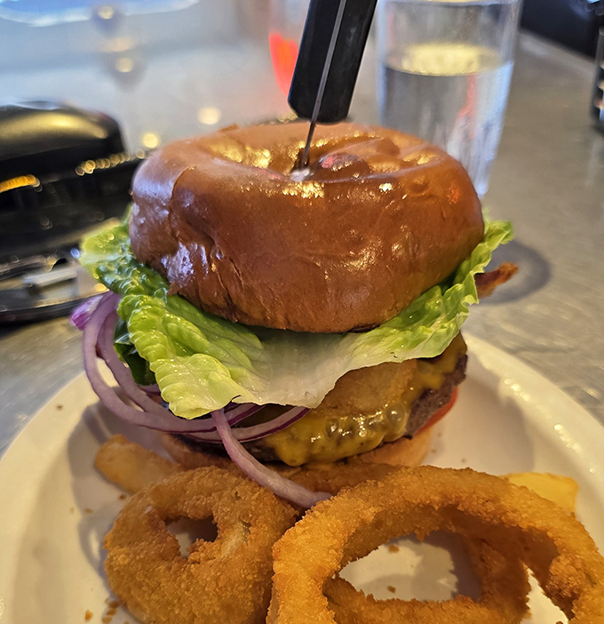 Not all burgers wear capes, but this one deserves superhero status with its perfectly toasted bun and golden onion rings riding shotgun.