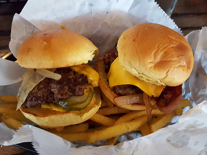 Two perfectly proportioned burgers nestled in a paper-lined basket with golden fries. Simple pleasures that make Monday feel like Friday.