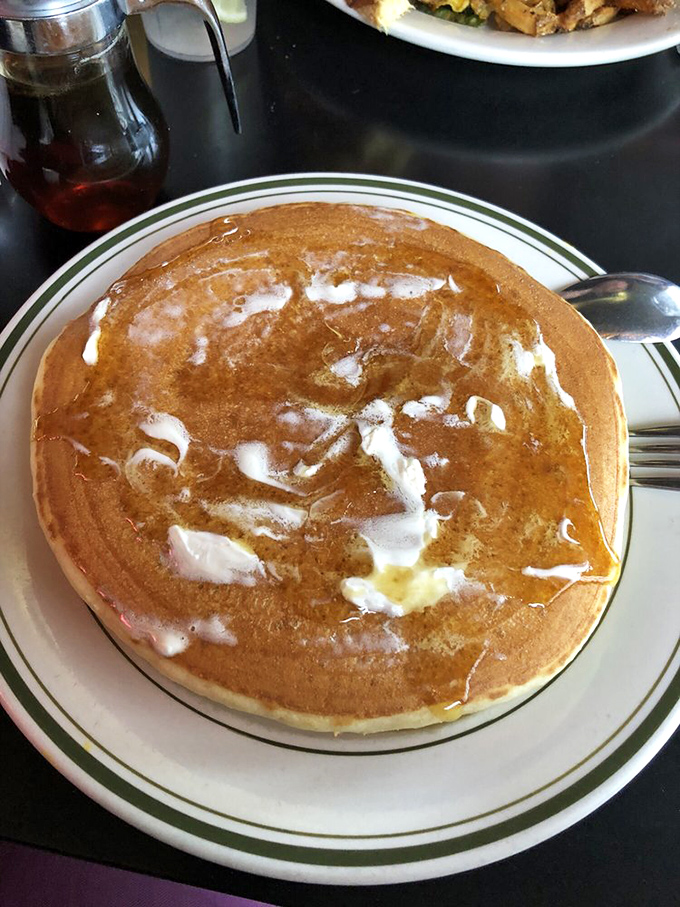 Behold the perfect pancake—golden-brown exterior giving way to cloud-like interior, with butter melting into those nooks and crannies like a warm embrace.