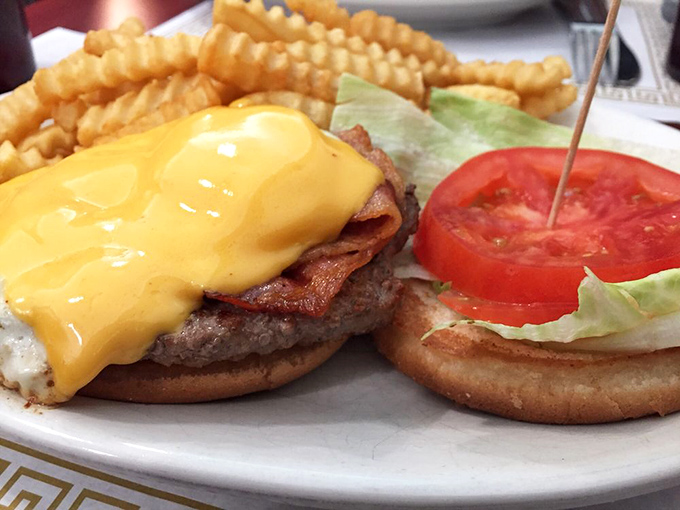 This isn't just a cheeseburger; it's a masterpiece of melty American cheese cascading over bacon and beef. The crinkle-cut fries are just showing off.