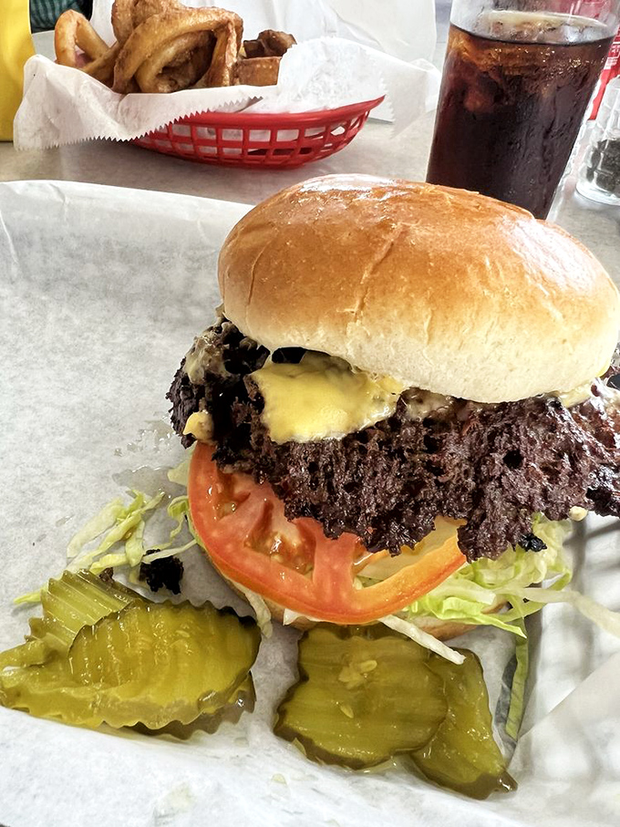 This magnificent burger beast arrives with crispy edges that would make any food scientist weep tears of joy.