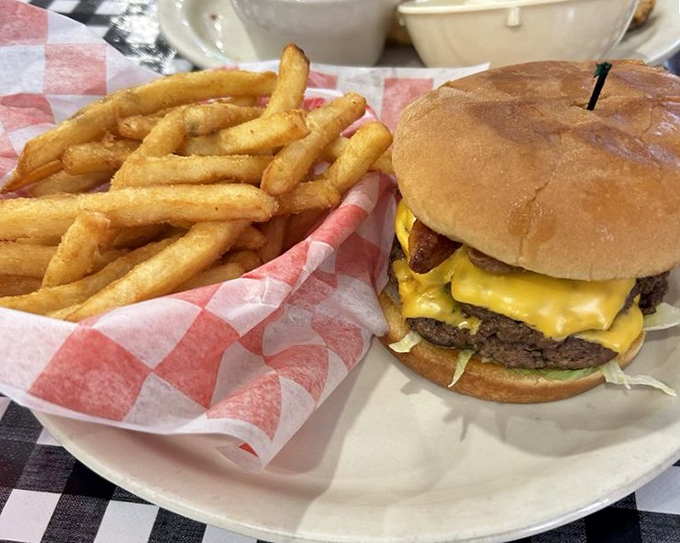Behold the cheeseburger that launched a thousand road trips, stacked high with golden cheese and zero regard for moderation.