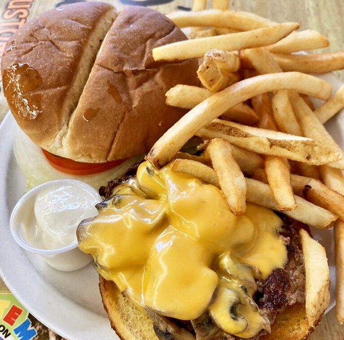 Melty cheese cascades over a perfectly grilled burger like a yellow waterfall of happiness. Those fries aren't just a side&mdash;they're co-stars.