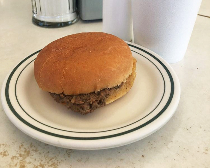 The star of the show in all its humble glory: a perfectly griddled slider on a soft bun, no pretension, just pure burger satisfaction.