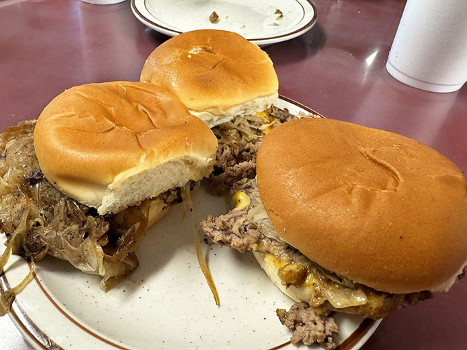 Three perfect specimens of burger artistry&mdash;thin patties with caramelized edges, melty cheese, and soft buns that prove simplicity is the ultimate sophistication.