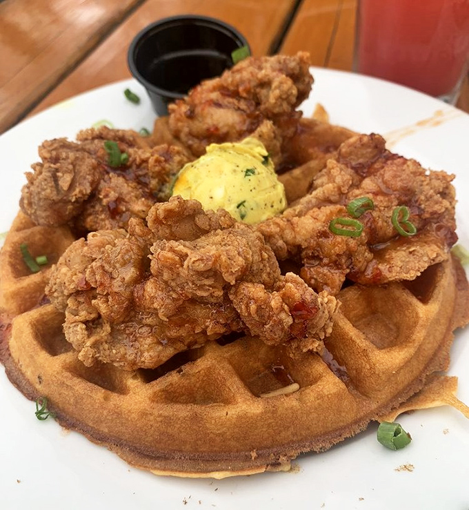 Behold the star attraction: golden-fried chicken perched atop a perfectly bronzed waffle, with herb butter slowly melting into those heavenly squares.