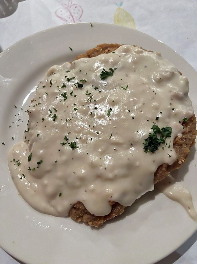 Behold the legendary chicken fried steak, drowning gloriously in cream gravy that would make your grandmother weep with joy.