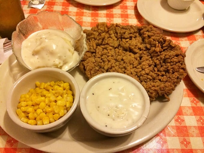 Behold the star attraction: a chicken fried steak that extends beyond its plate boundaries, accompanied by creamy sides that know their supporting role.